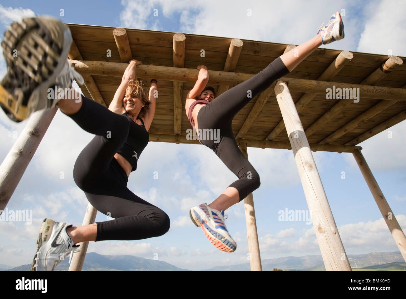 Two Women Hanging From Wooden Structure Stock Photo - Alamy