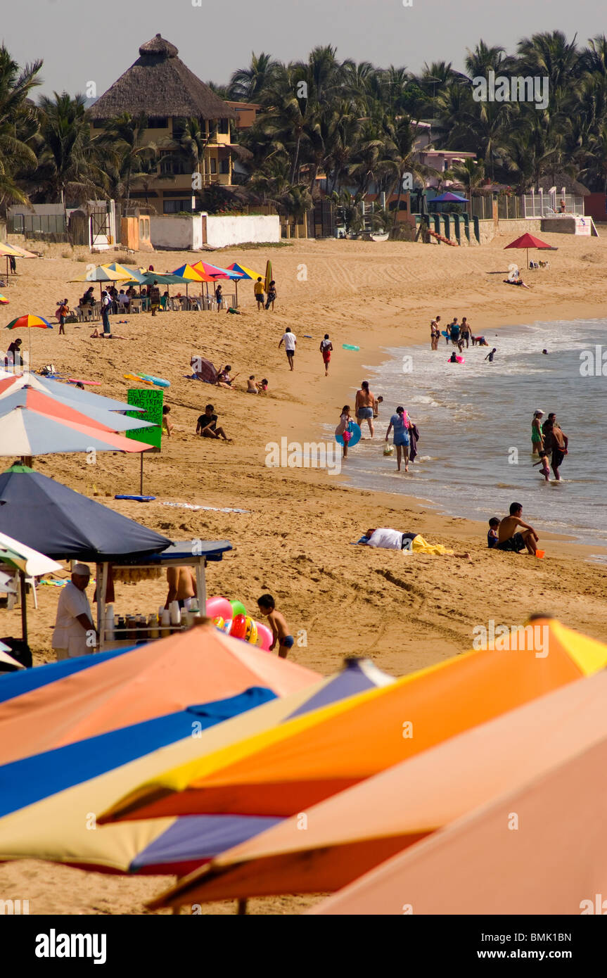 Umbrella filled shoreline and people enjoying the beach, Melaque Beach ...