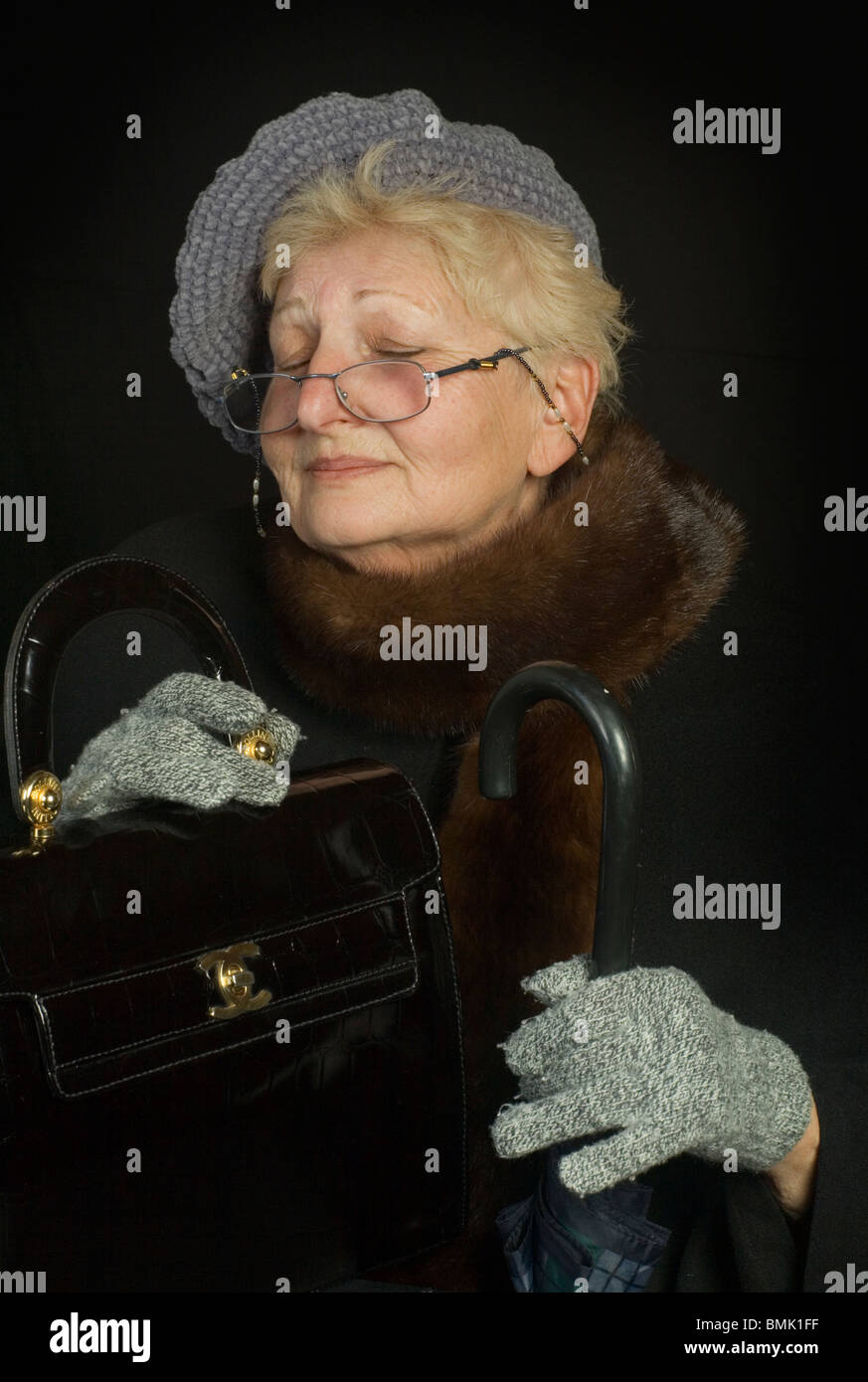 An elderly, very elegant and old fashioned lady dressed up with a very ...