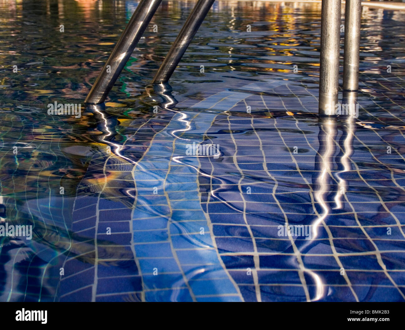 Reflections in the water and a ladder by a poolside Stock Photo - Alamy