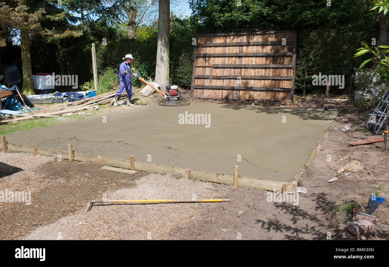man leveling concrete base with power float Stock Photo - Alamy