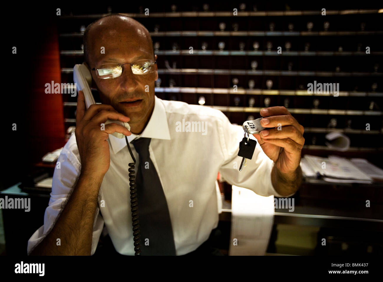 A hotel concierge handing room keys and talking on the phone. Rome ...