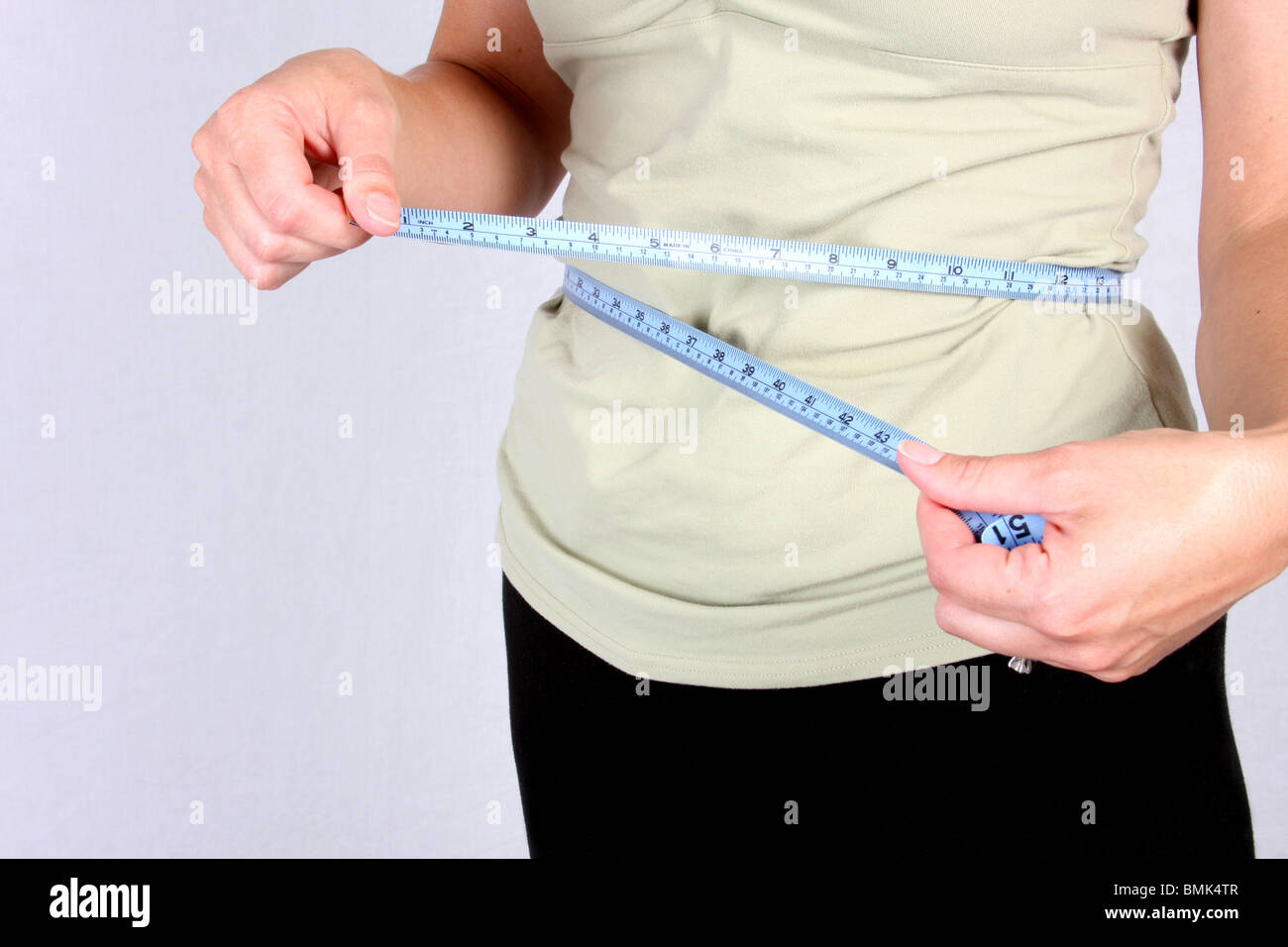 Young woman holding a ruler around her waist Stock Photo - Alamy