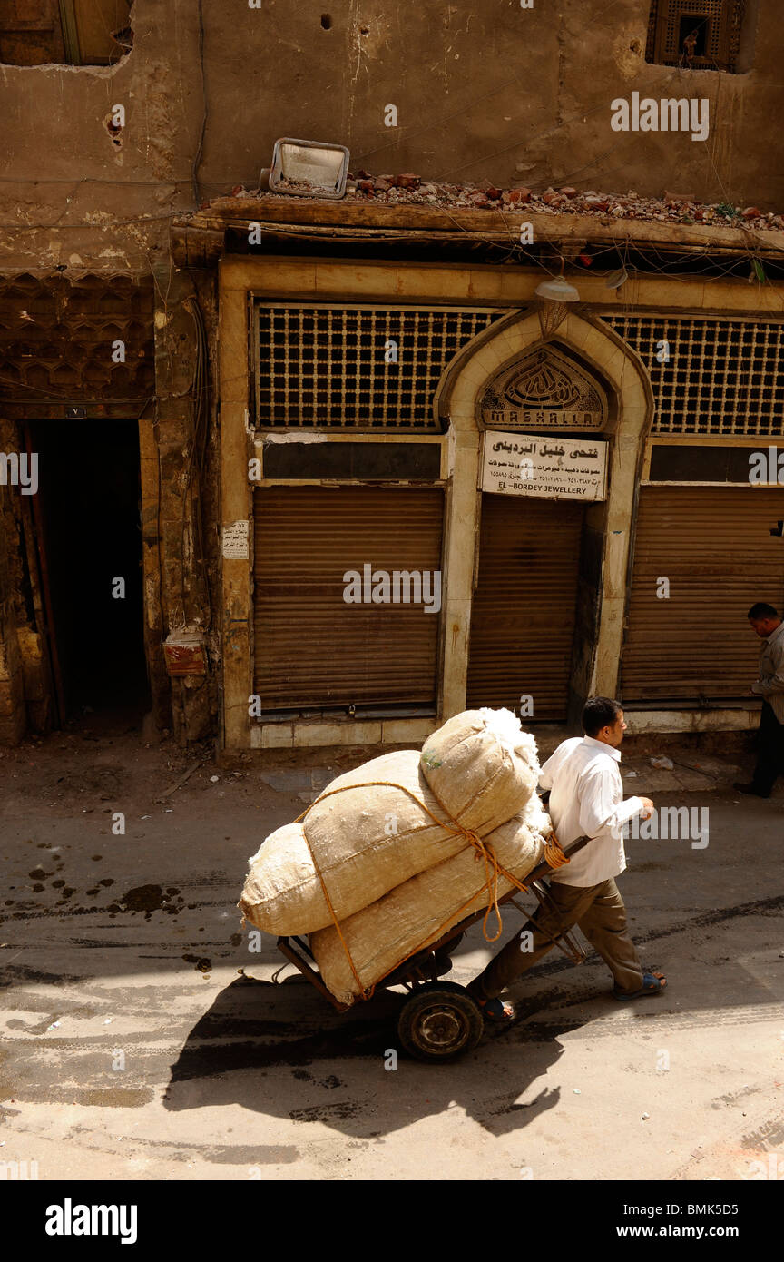 egyptian labourer pulling cart laden with goods , early morning scene ...