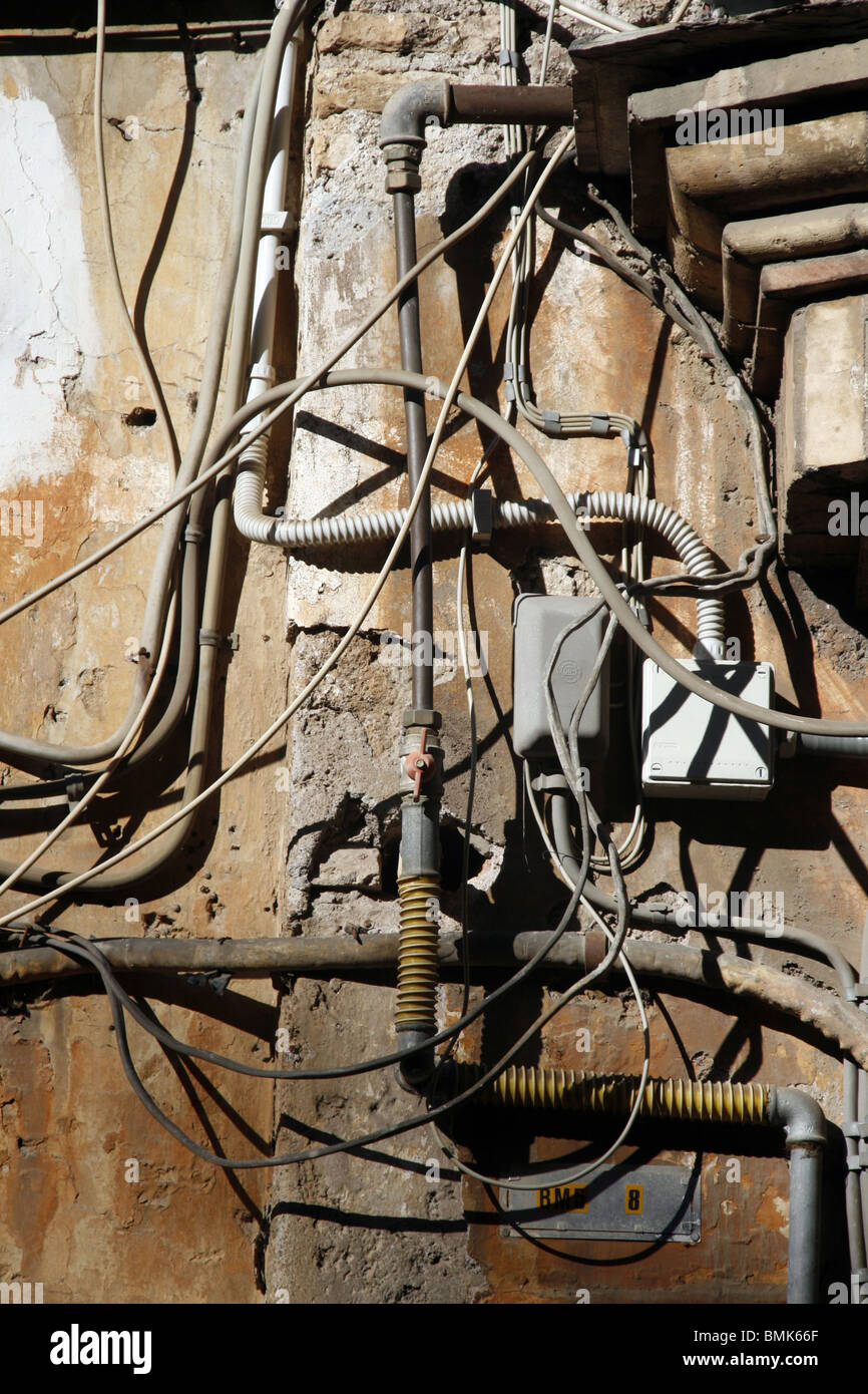 electricity power wiring circuit cables tubes on side of property wall ...