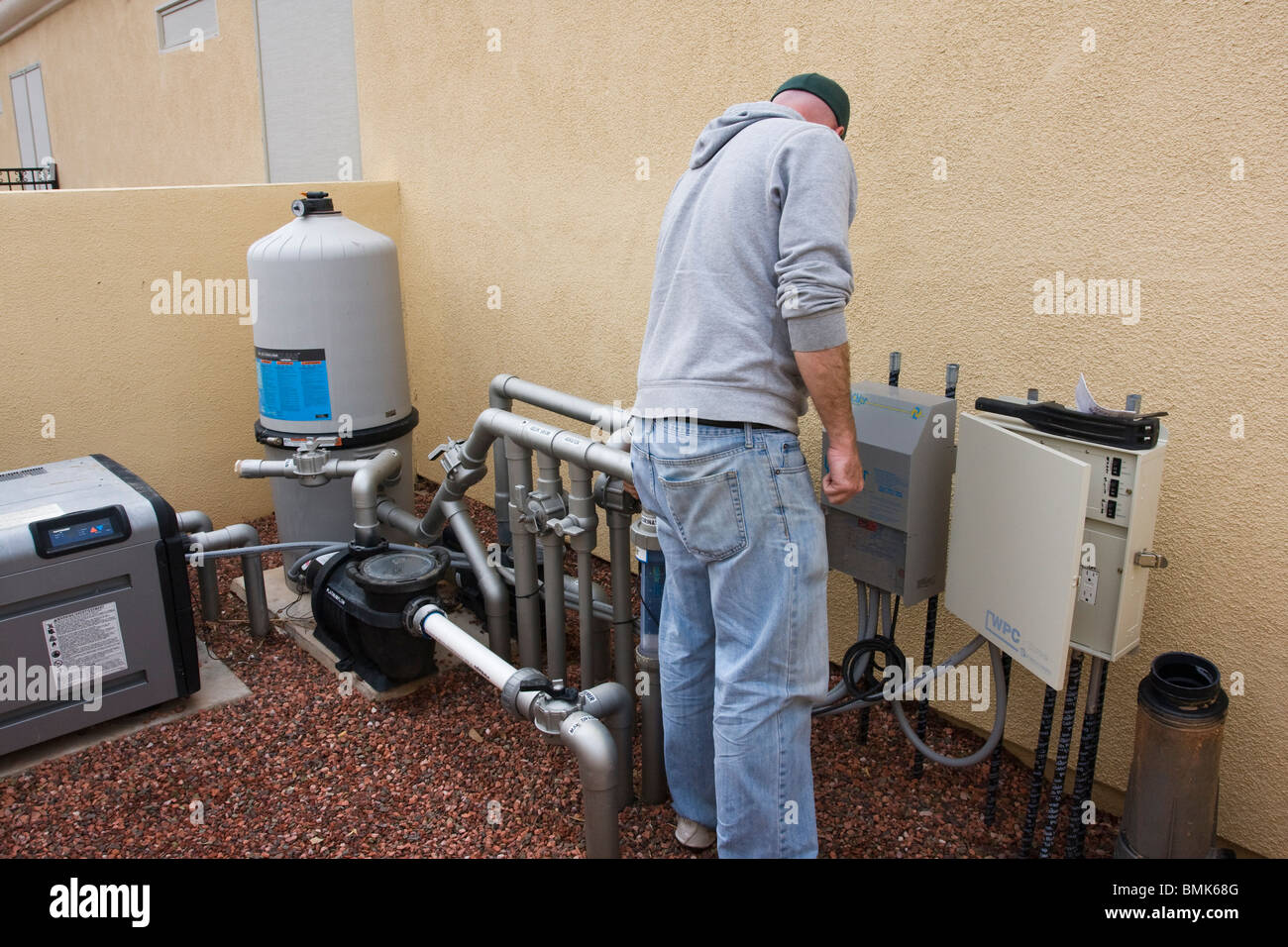 Man turning valve of a swimming pool system Stock Photo - Alamy