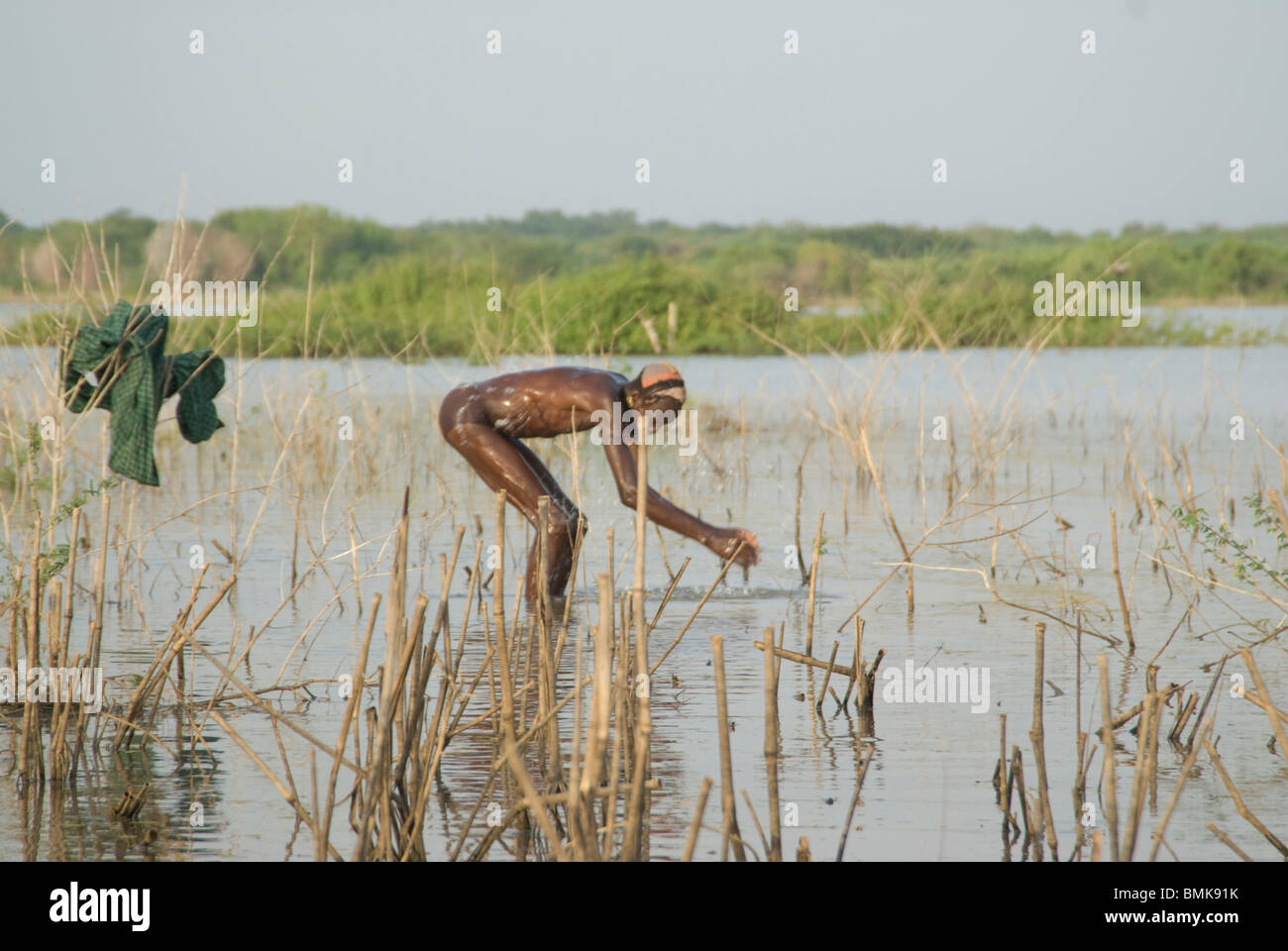 Ethiopia: Lower Omo River Basin, Lebuk farm villager bathing in flooded ...