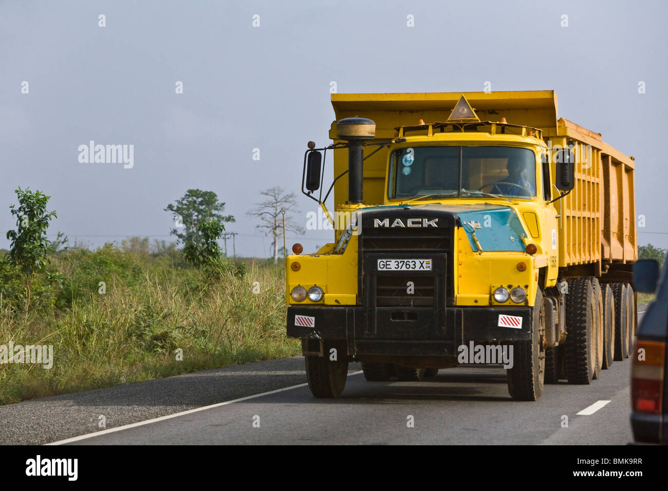Africa, West Africa, Ghana, Coastal Road. Yellow Mack truck travelling ...