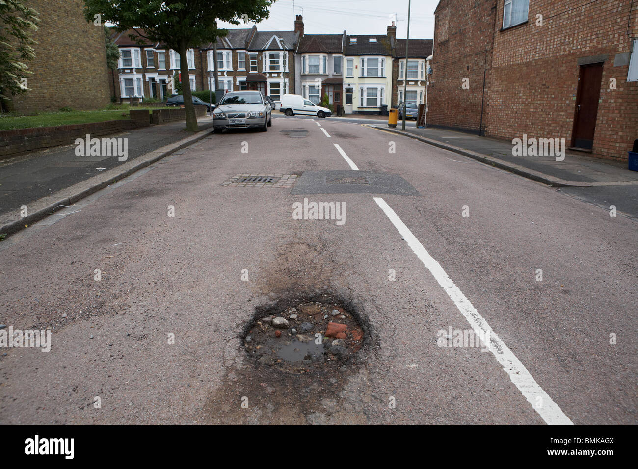 Pot holes in a suburban road in North London Stock Photo - Alamy