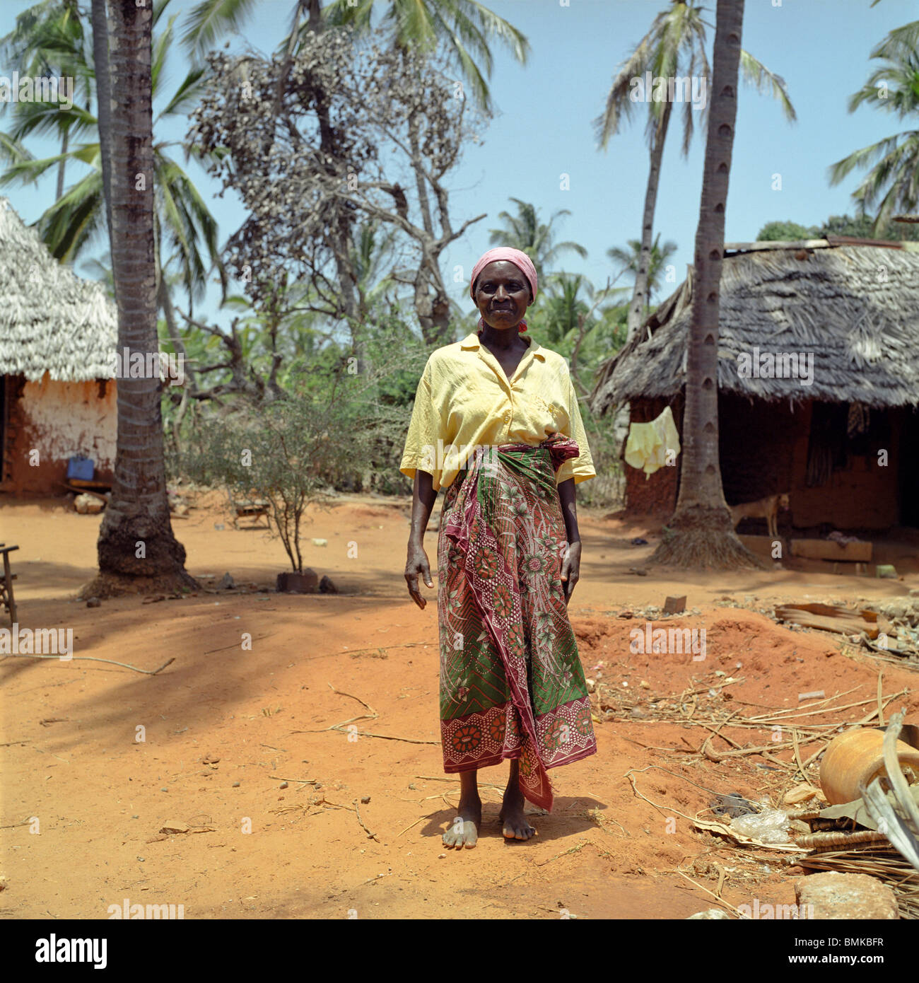 older kenyan african woman standing barefoot on the ground amongst ...