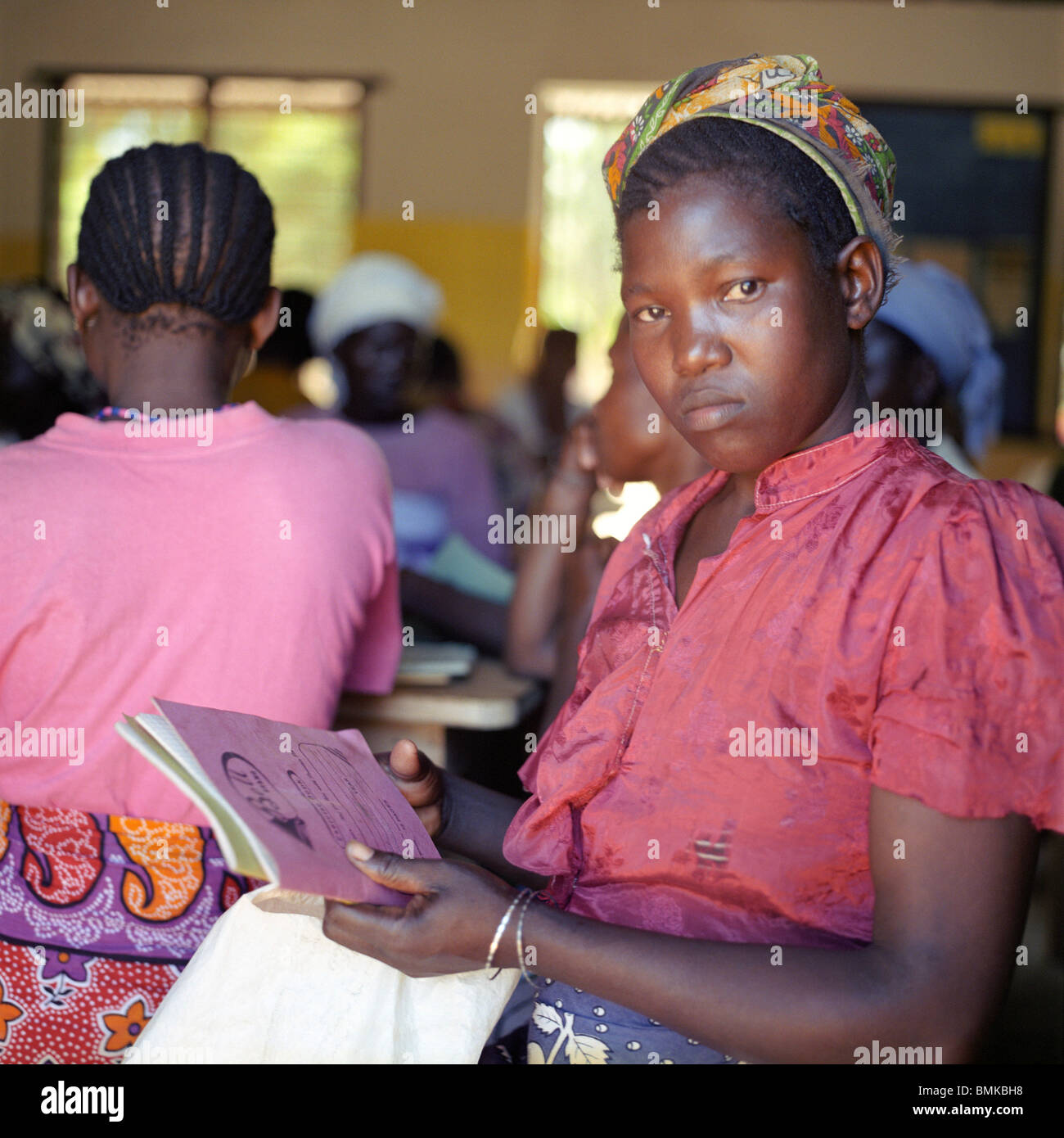 Woman in kenya africa holding her school book facing camera in an adult ...