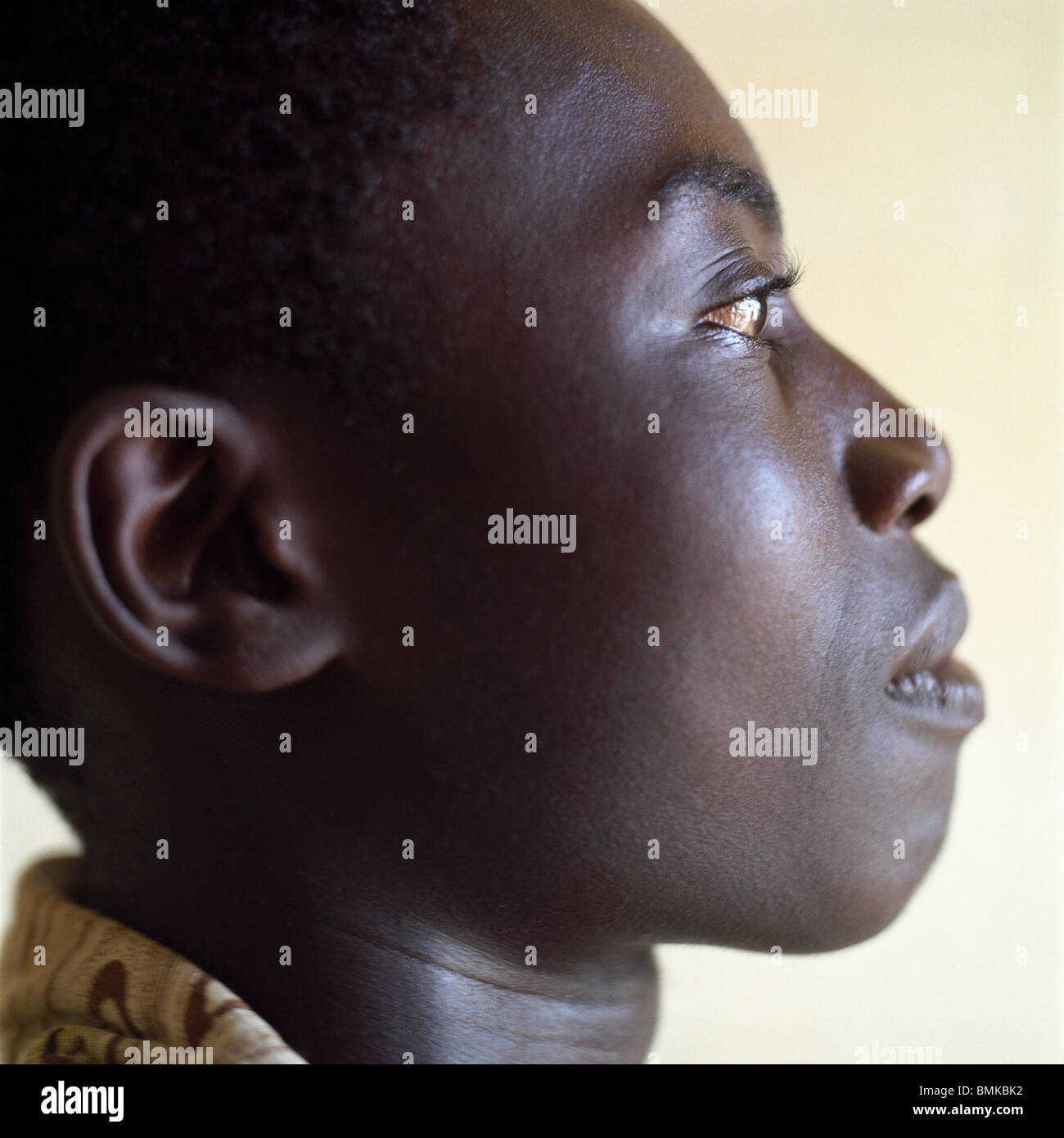 Teenaged african boy in kenya side view from camera looking serious to ...