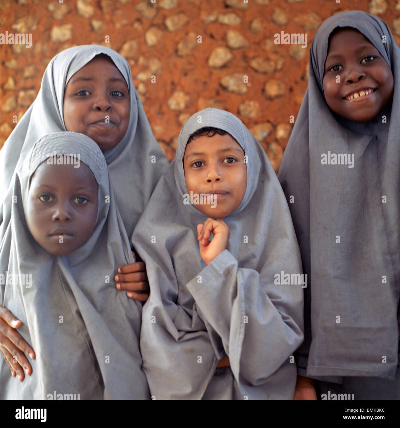 Young african muslim girls in Kenya in front of a mud hut in a ...