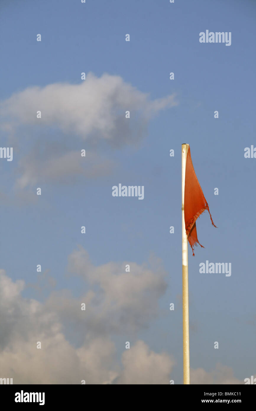 one old red warning flag flying in wind by beach Stock Photo - Alamy
