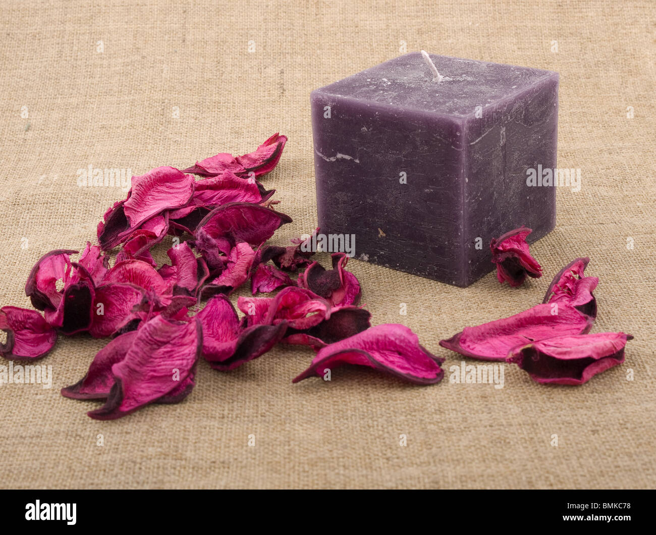 Aromatic purple candle with pink potpourri on linen background Stock ...