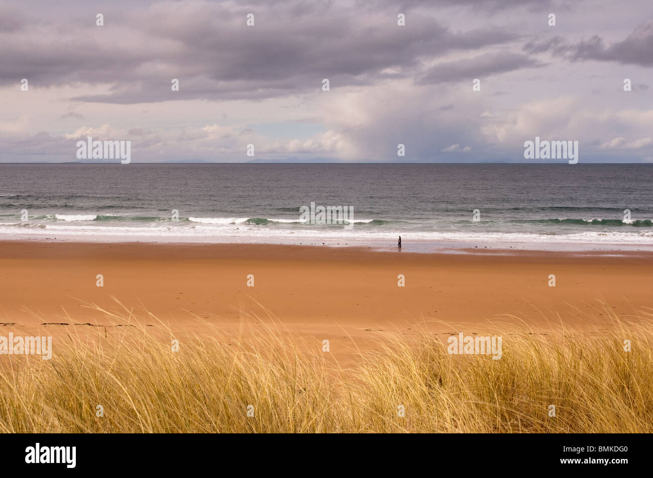 A woman walking on the deserted beach at Red Point, Scottish Highlands ...