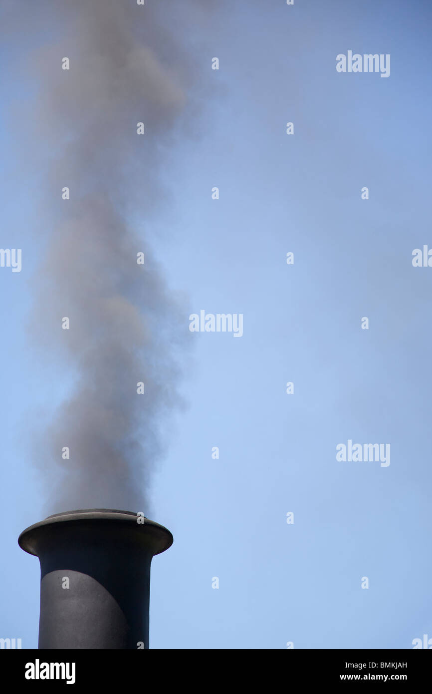Chimney pot of a railway steam engine emitting smoke and pollution into ...