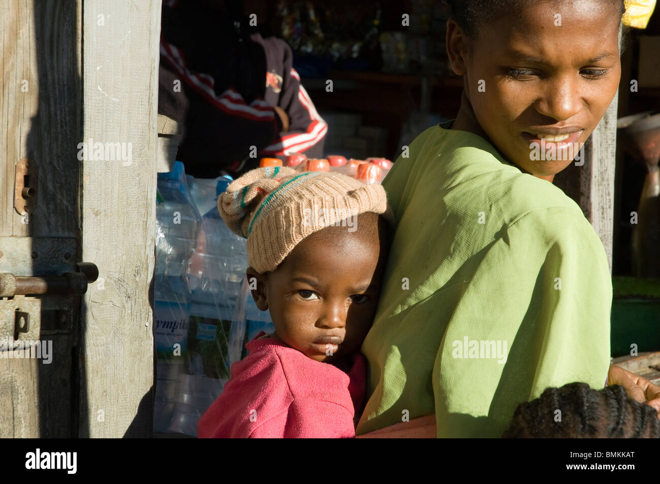 Madagascar, Ranohira. Scared young boy gets closer to his mother Stock ...