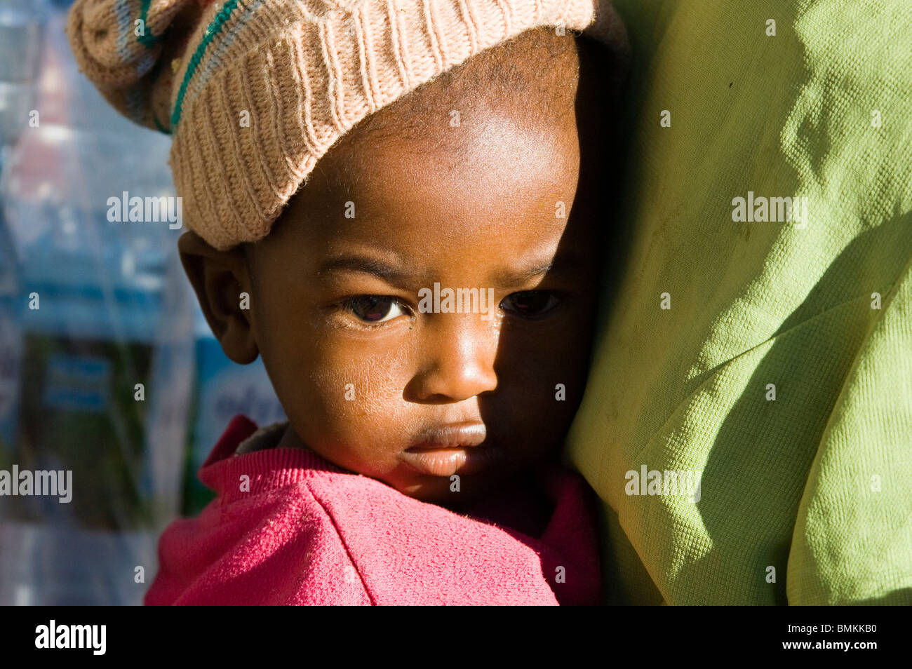 Madagascar, Ranohira. Scared young boy gets closer to his mother Stock ...