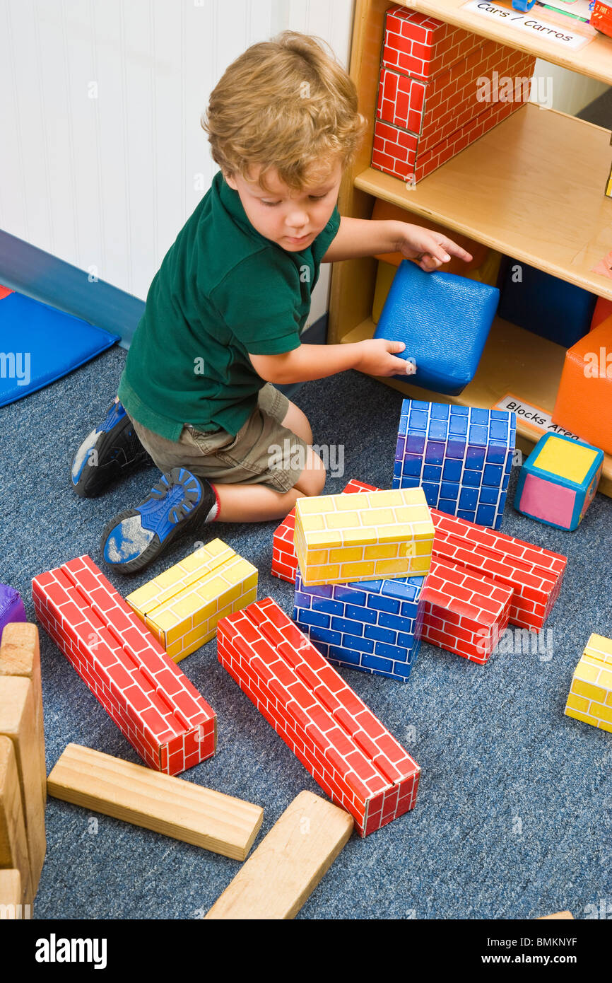 Preschooler boy playing in the classroom with building blocks Stock ...