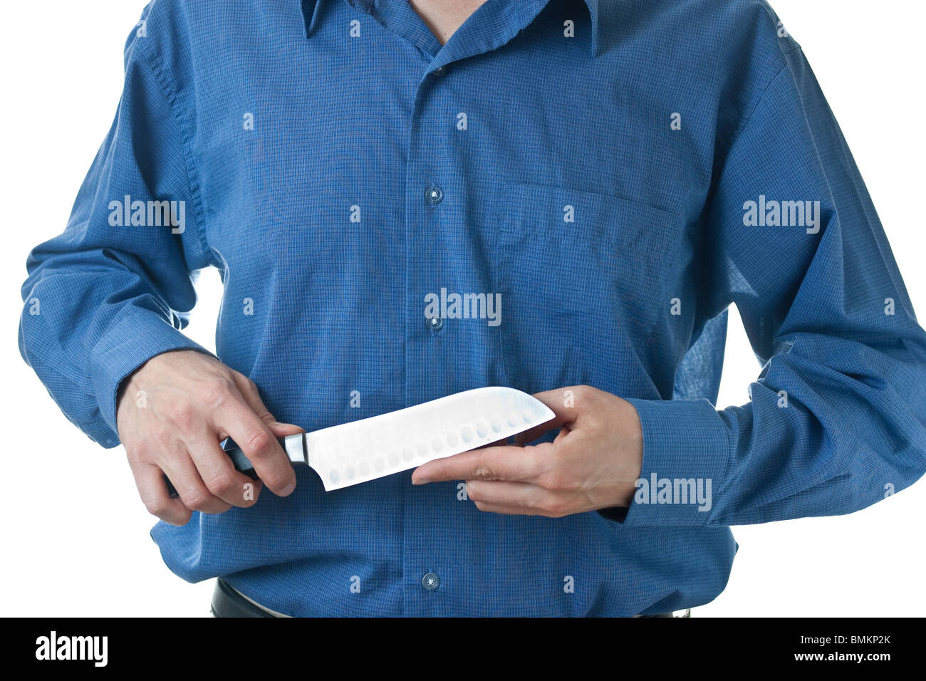 The mid-section of a man in a blue dress shirt, holding a large knife ...