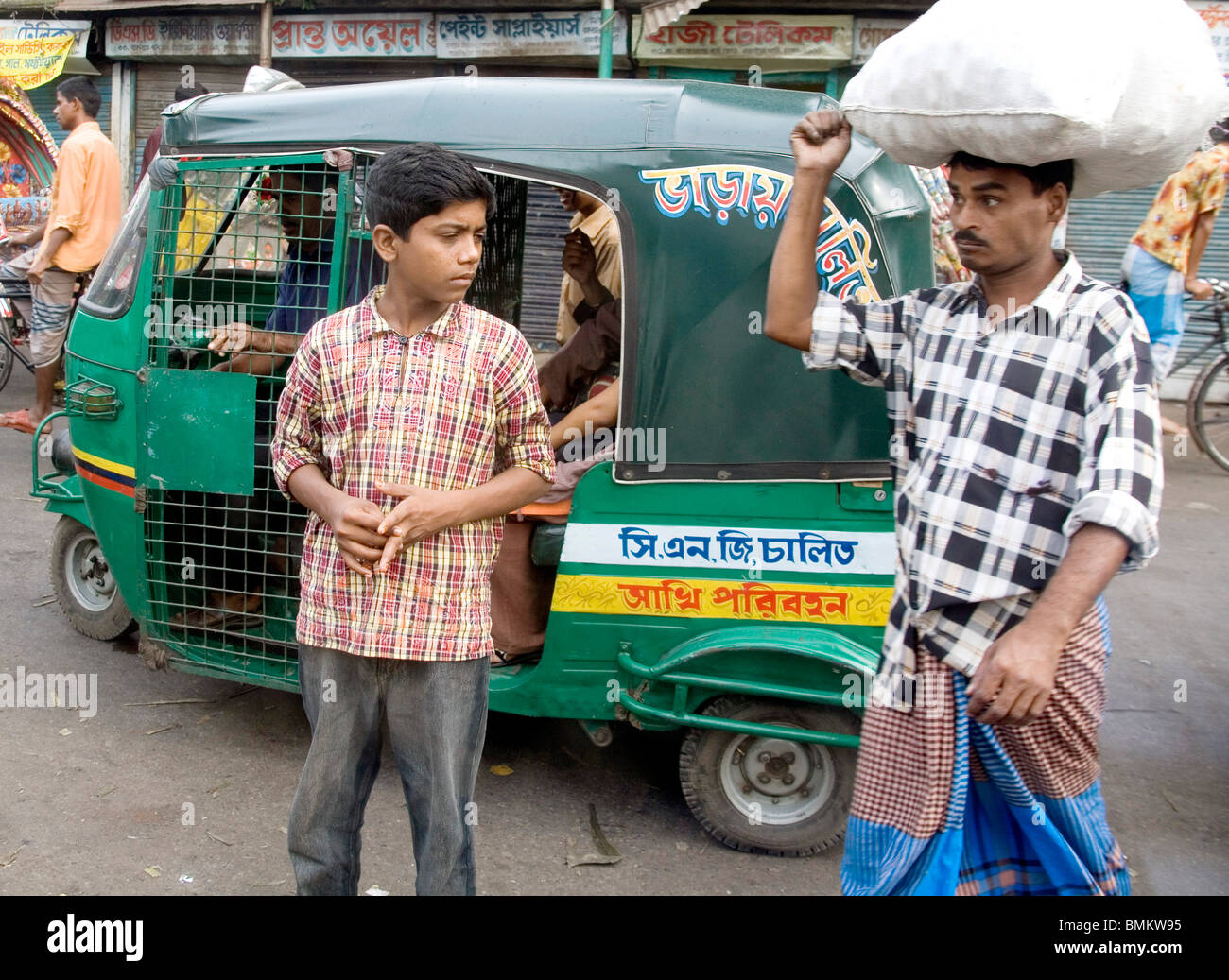 Street scene muslim man and boy standing at green tempo auto rickshaw ...