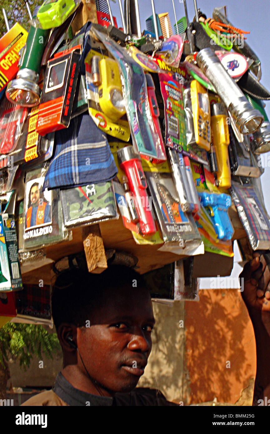 Niger, Niamey, African itinerant merchant carrying a full load of ...