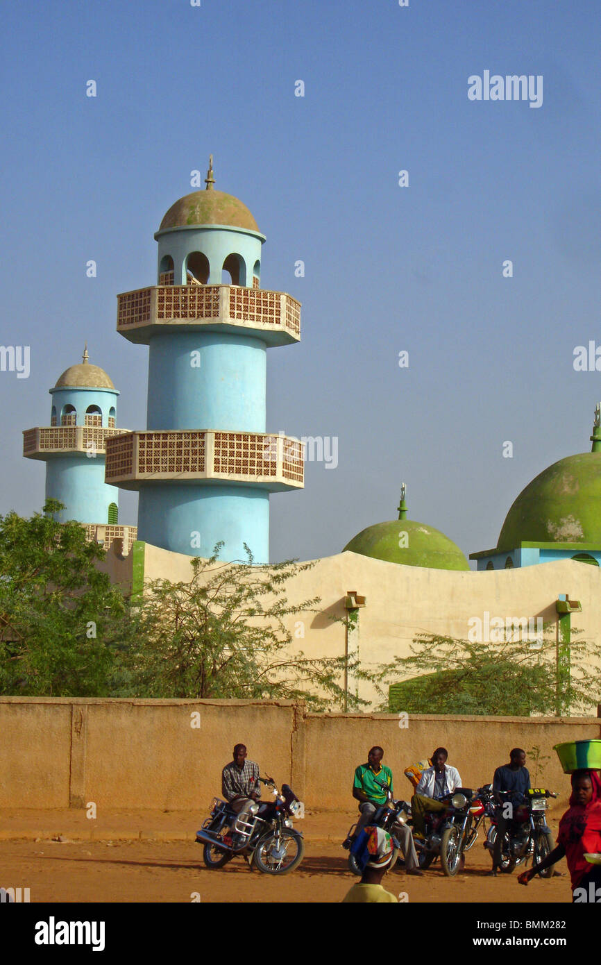 Niger. Zinder, Moto taxi parked in front of a blue and green mosque, in ...