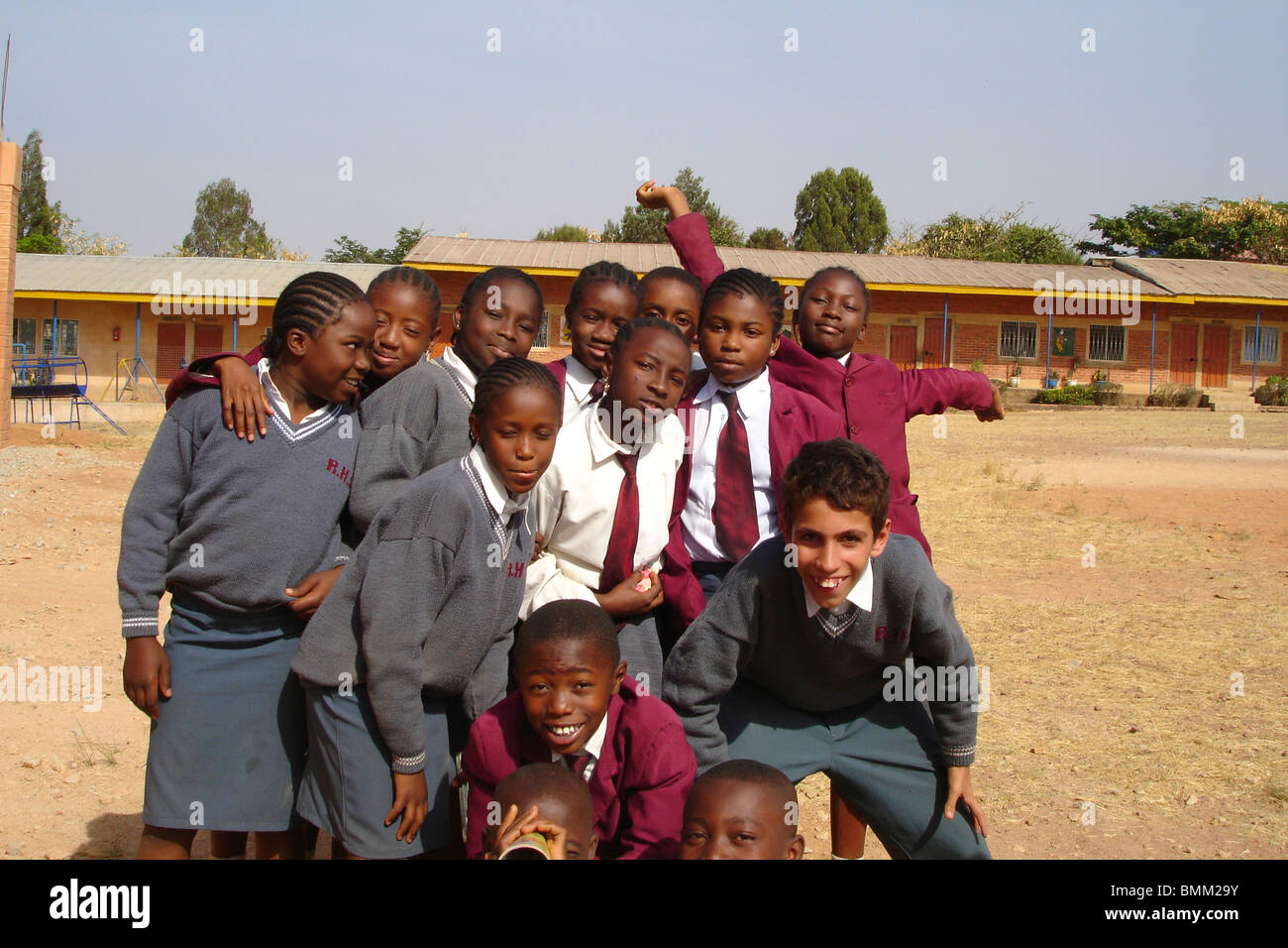 Pupils wearing their purple and grey school uniform taking a group ...