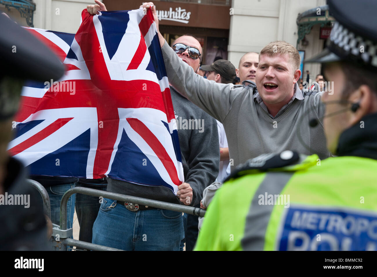 EDL protesters shout abuse and hold Union Jack behind police and ...