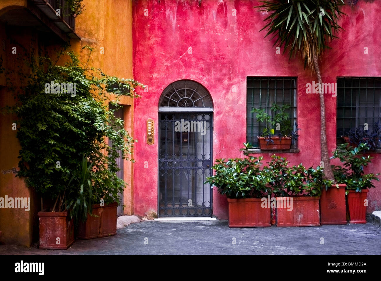 Facade of a colorful house in Rome (Italy), revealing part of a balcony ...