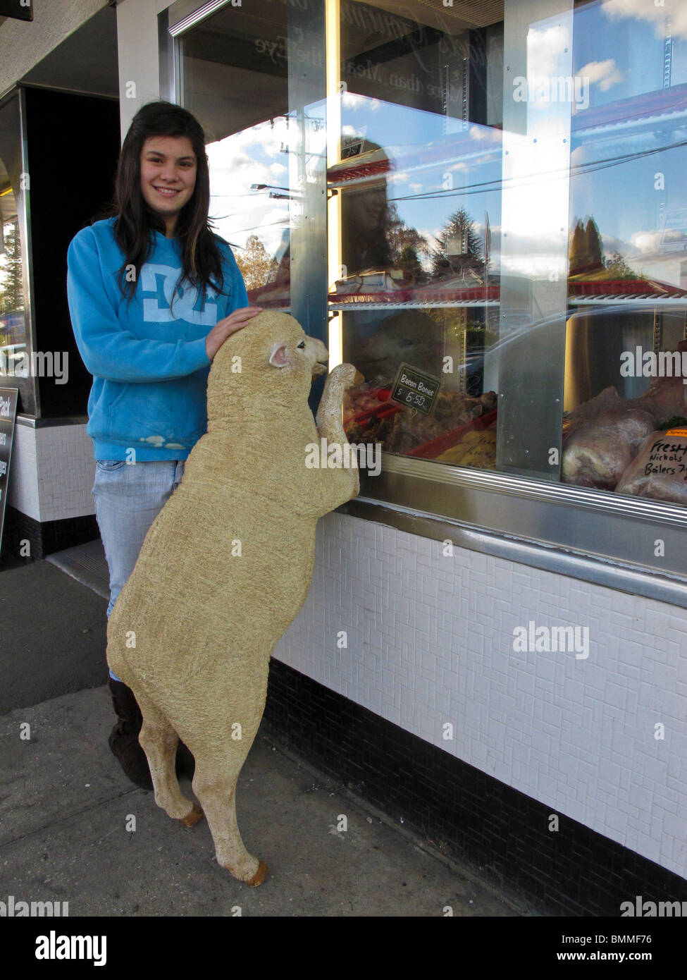 A young girl with a humorous promotional sales gimmick of a model sheep ...