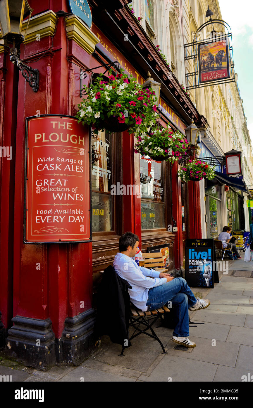 young man street uk sitting alone on sidewalk terrace front of ...