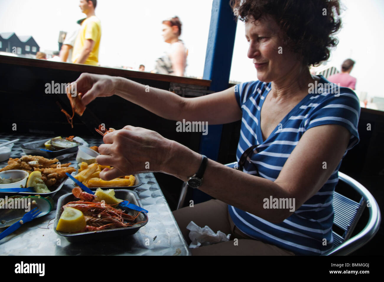 Woman eating fish and chips restaurant hi-res stock photography and ...