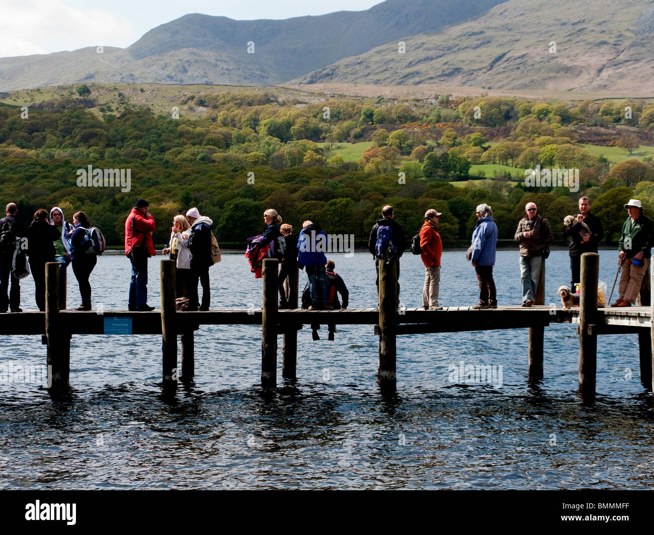 People waiting on pier for ferry over Coniston Water, England Stock ...