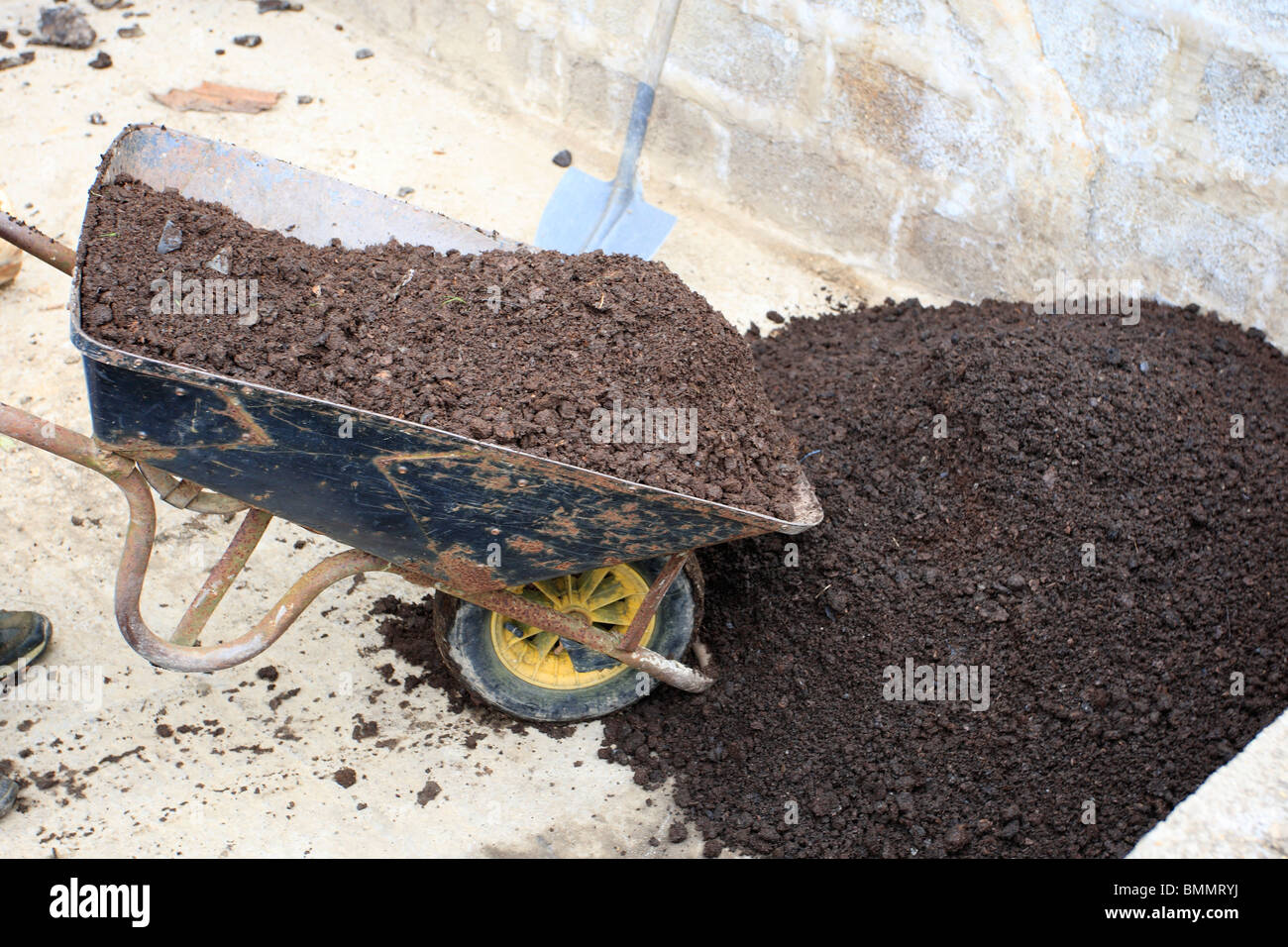 TIPPING SIEVED COMPOST FROM WHEELBARROW Stock Photo - Alamy
