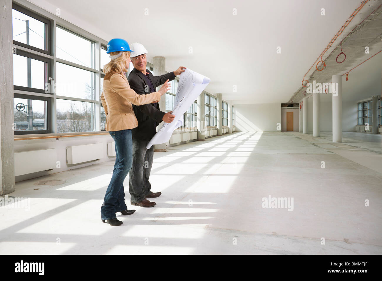 Two architects examining office building Stock Photo - Alamy