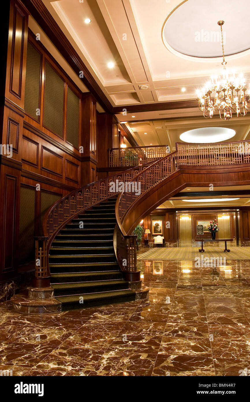 A carpeted curved staircase in a brightly lit tradional lobby Stock ...