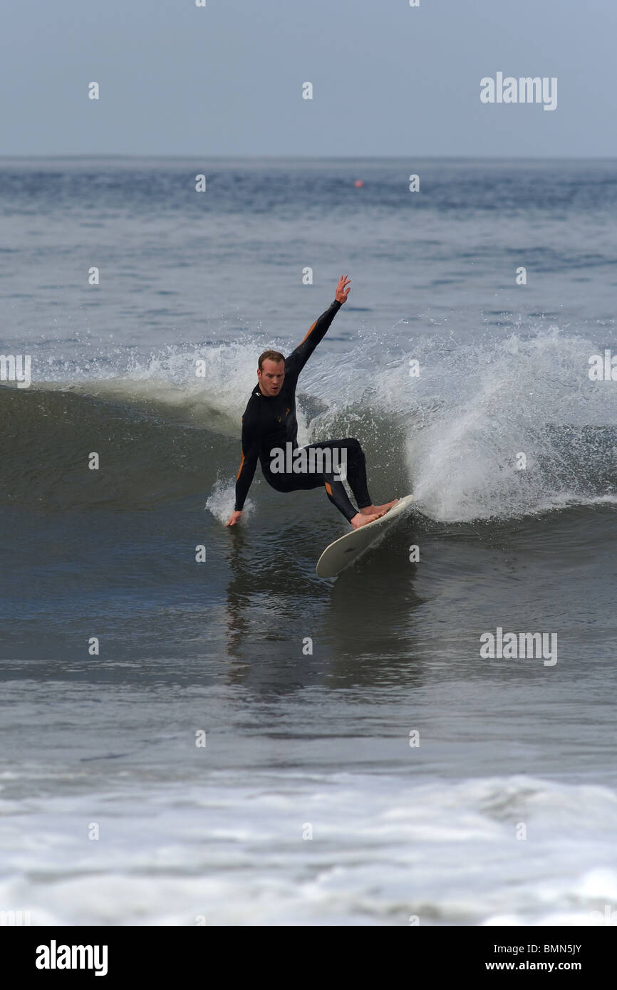 Surfer performs cutback with surfboard on edge and one hand trailing in ...