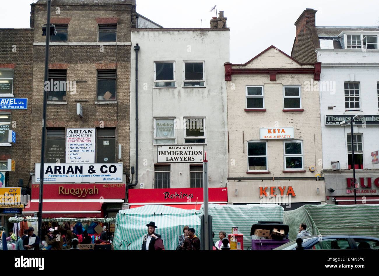 Row of shops, immigration lawyers and street market Whitechapel high ...