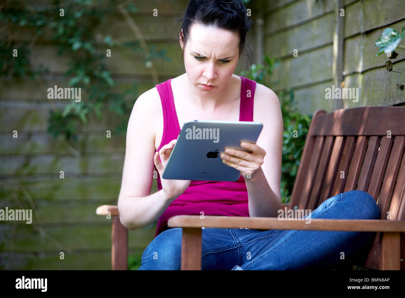 A woman uses a Ipad in the garden Stock Photo - Alamy