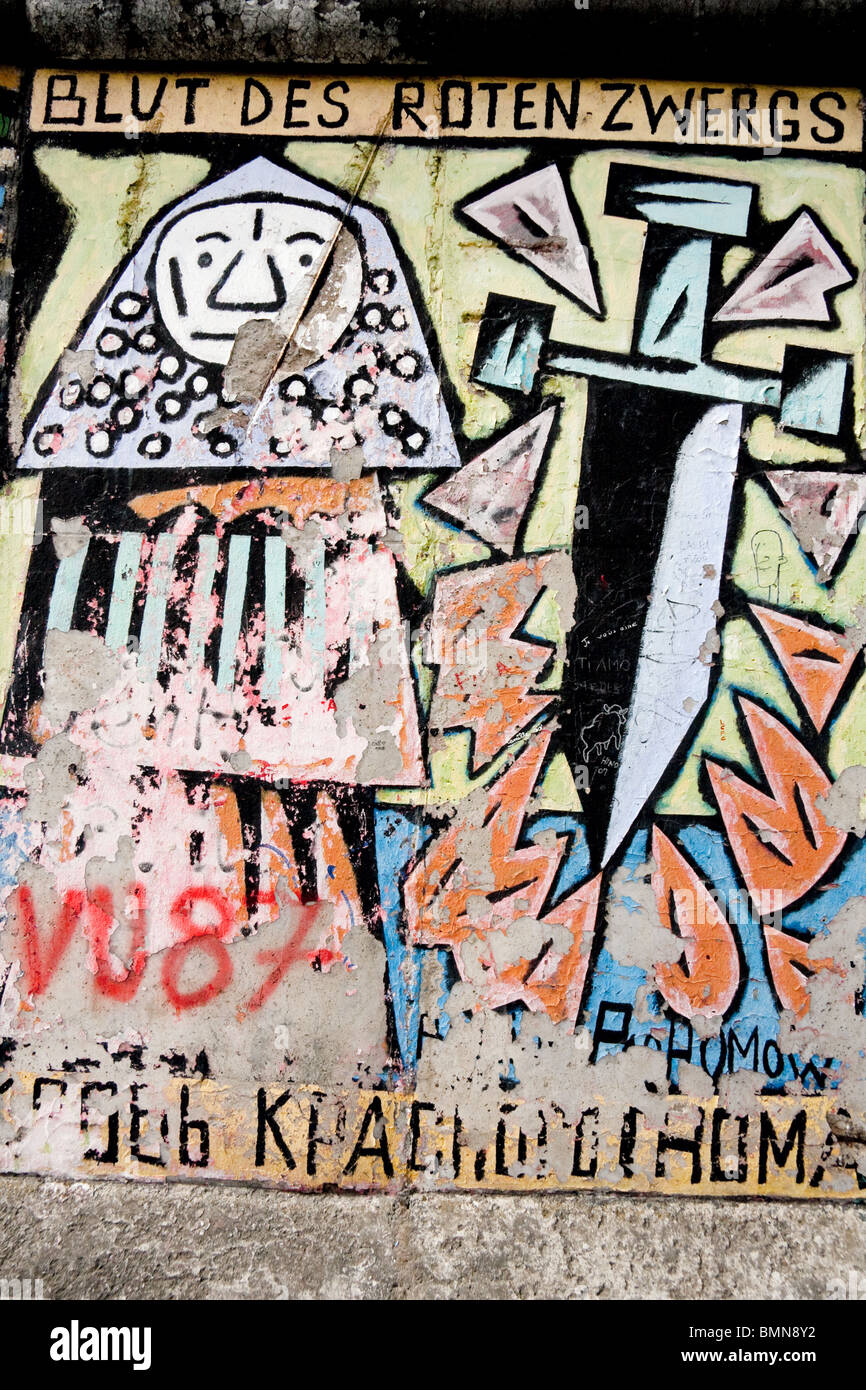 graffiti on a section of the Berlin Wall with sword and figure and word ...