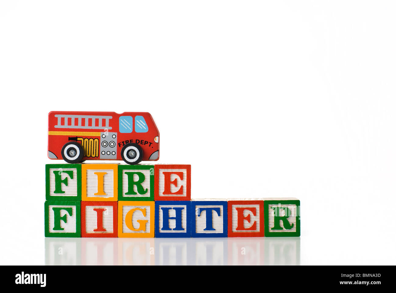 Colorful children's blocks spelling FIREFIGHTER with a toy fire truck ...