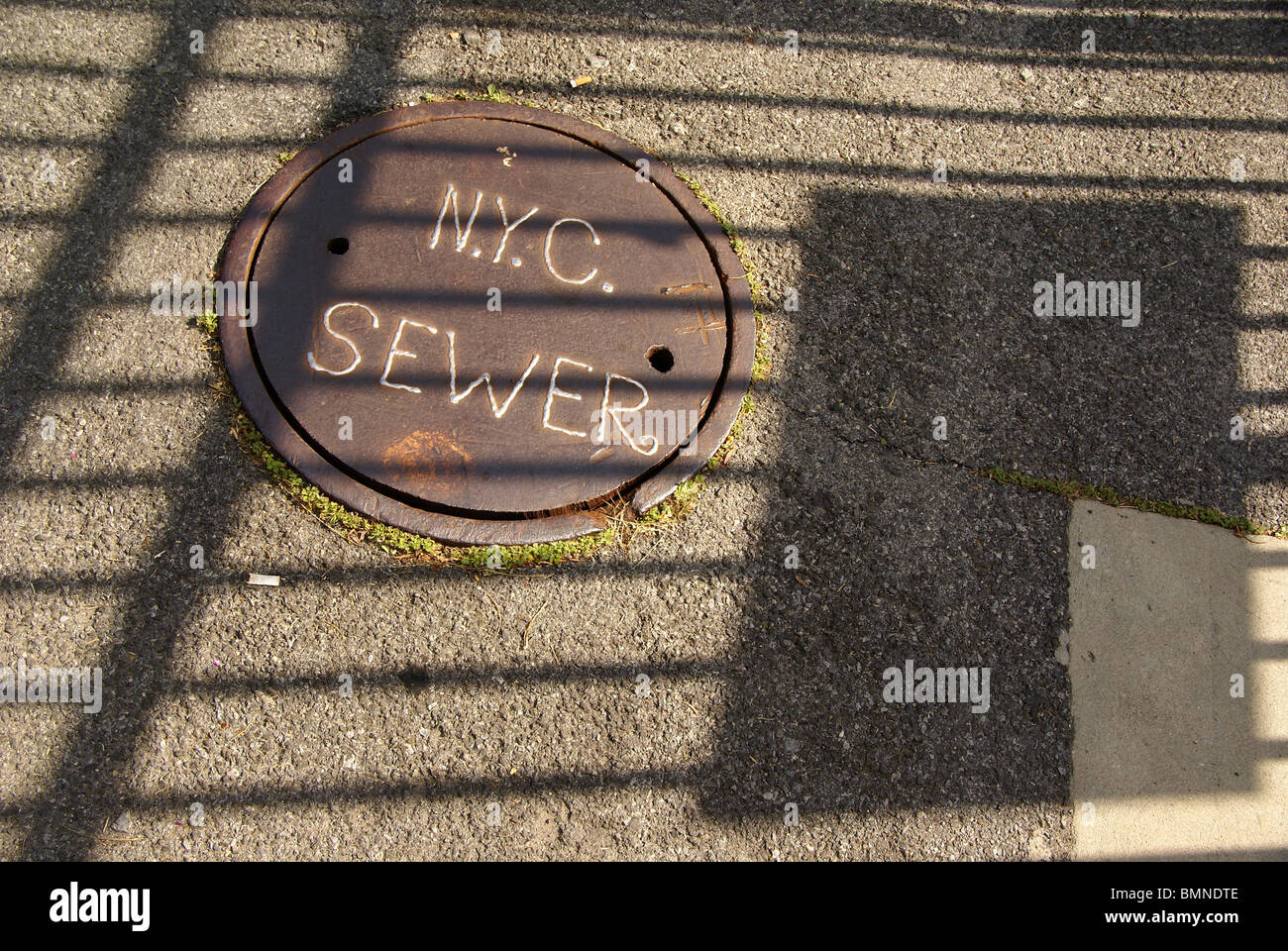 Manhole cover in NYC with a sign NYC sewer. Positioning of the cover ...