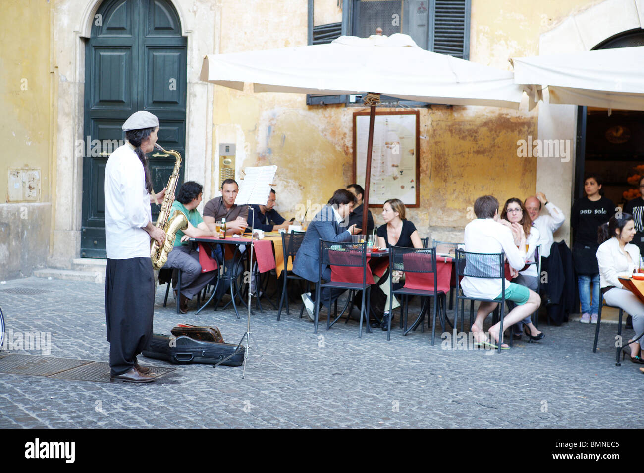 One man play music with a saxophone in the street in front of Rome ...