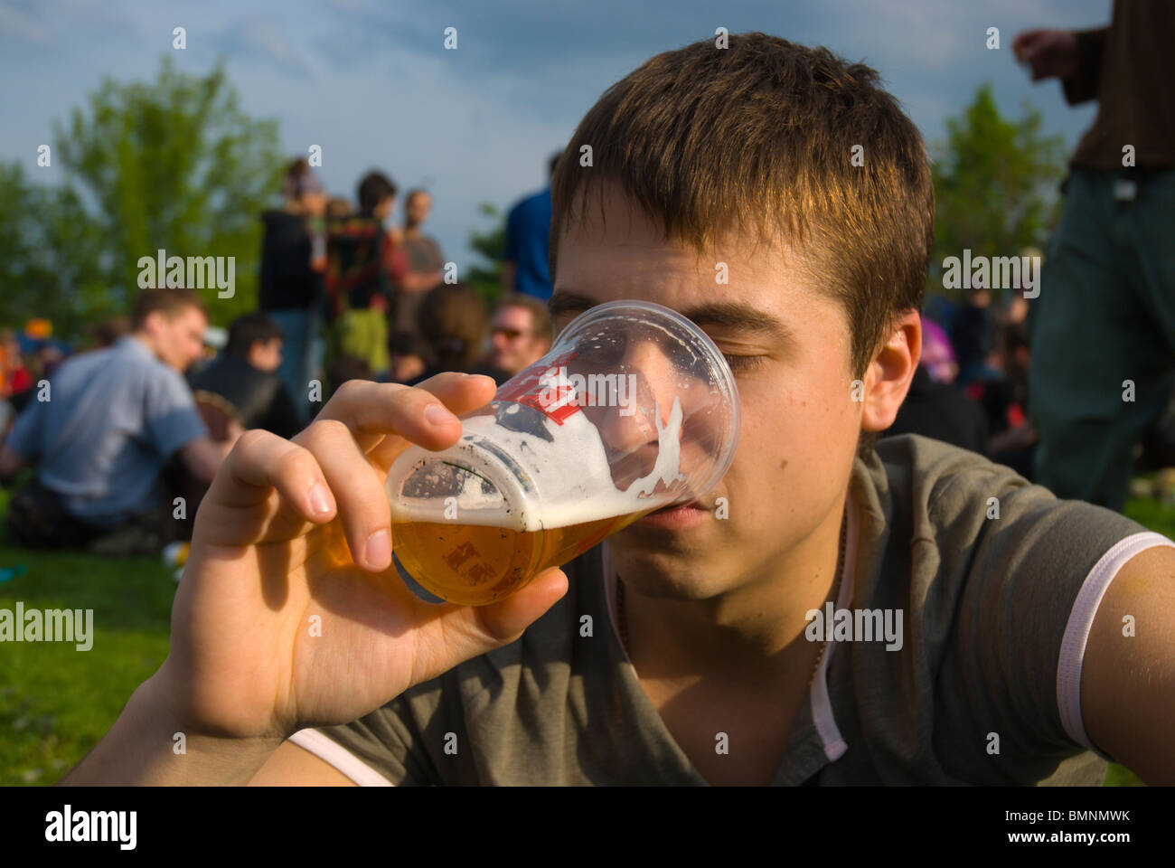 Russian man in his 20s drinking beer out of plastic cup Zizkov district ...