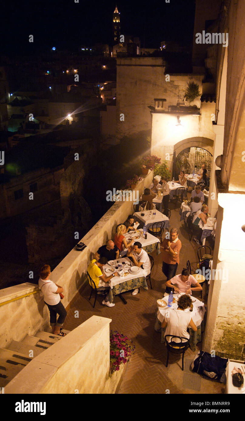Night image of people eating an evening meal in a busy Italian ...