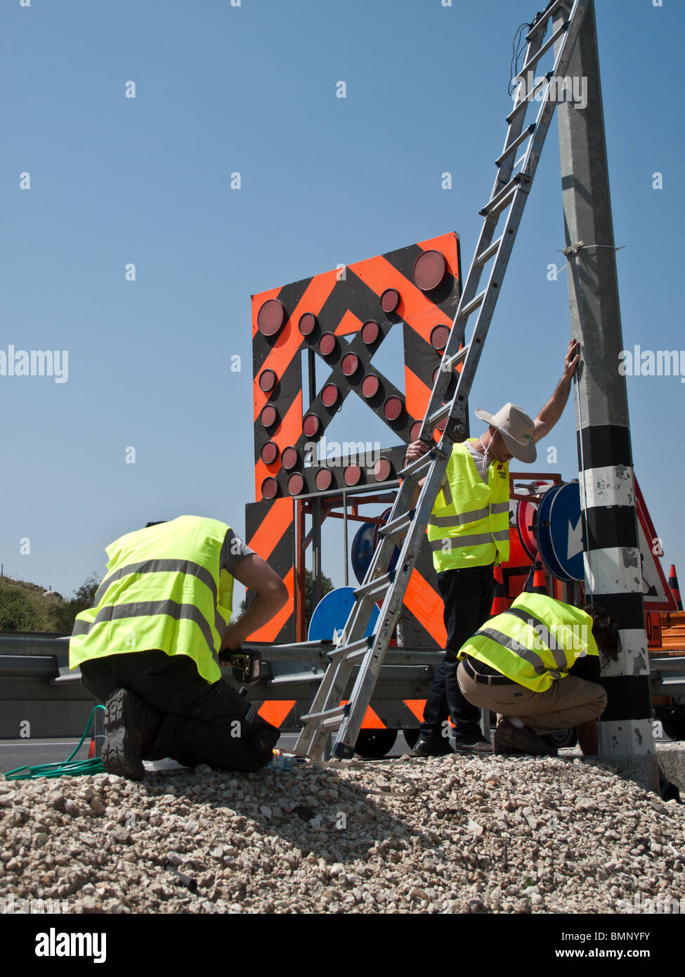 Men at work on side of road with ladder and safety equipment Stock ...
