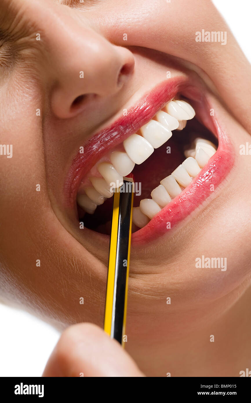 Close-up of stressed Caucasian woman biting pencil on white background ...