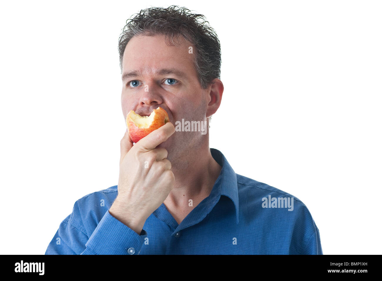 A man in a blue dress shirt, eating an apple, isolated on white Stock ...